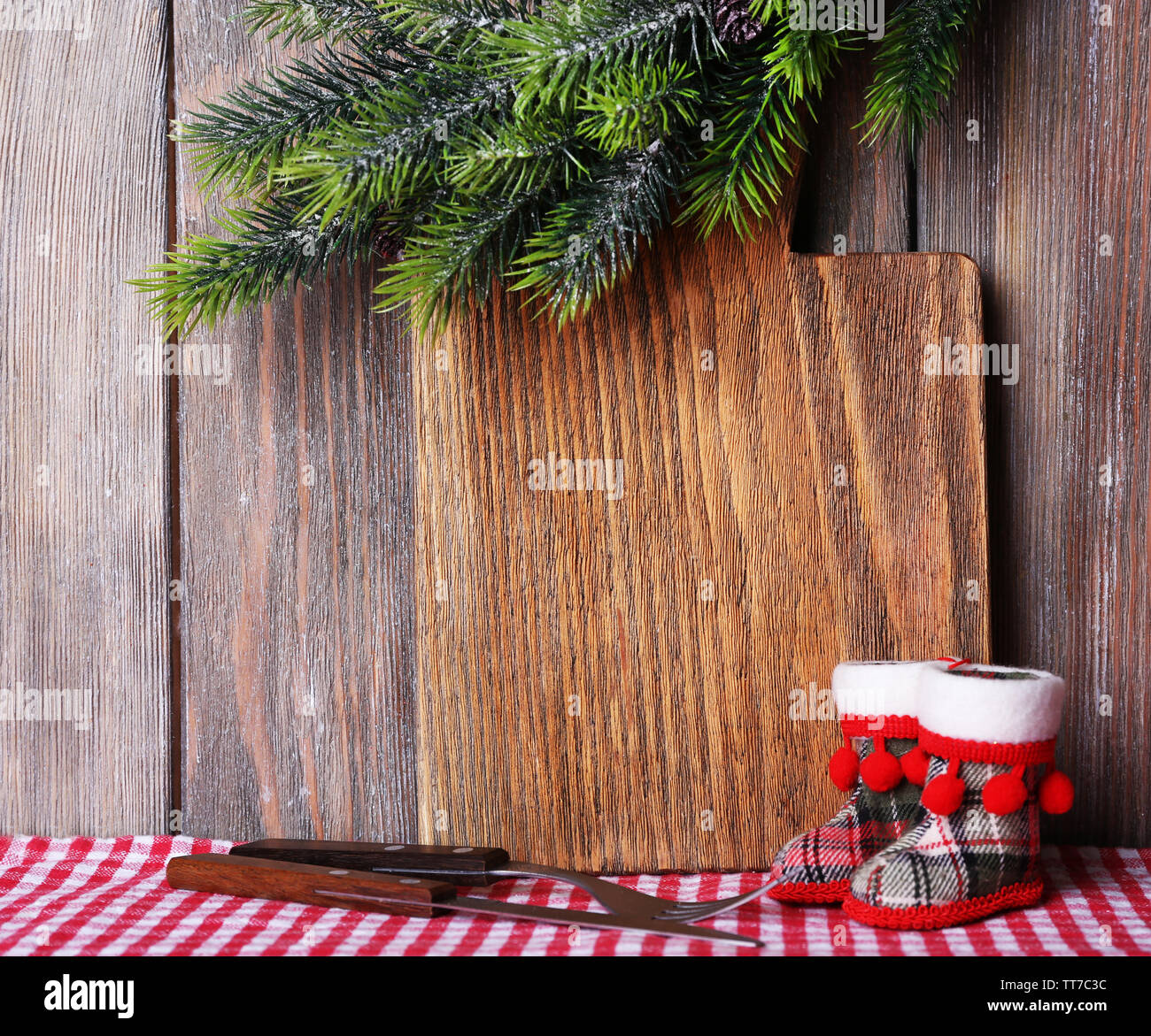 Cutting board with Christmas decoration on wooden planks background ...