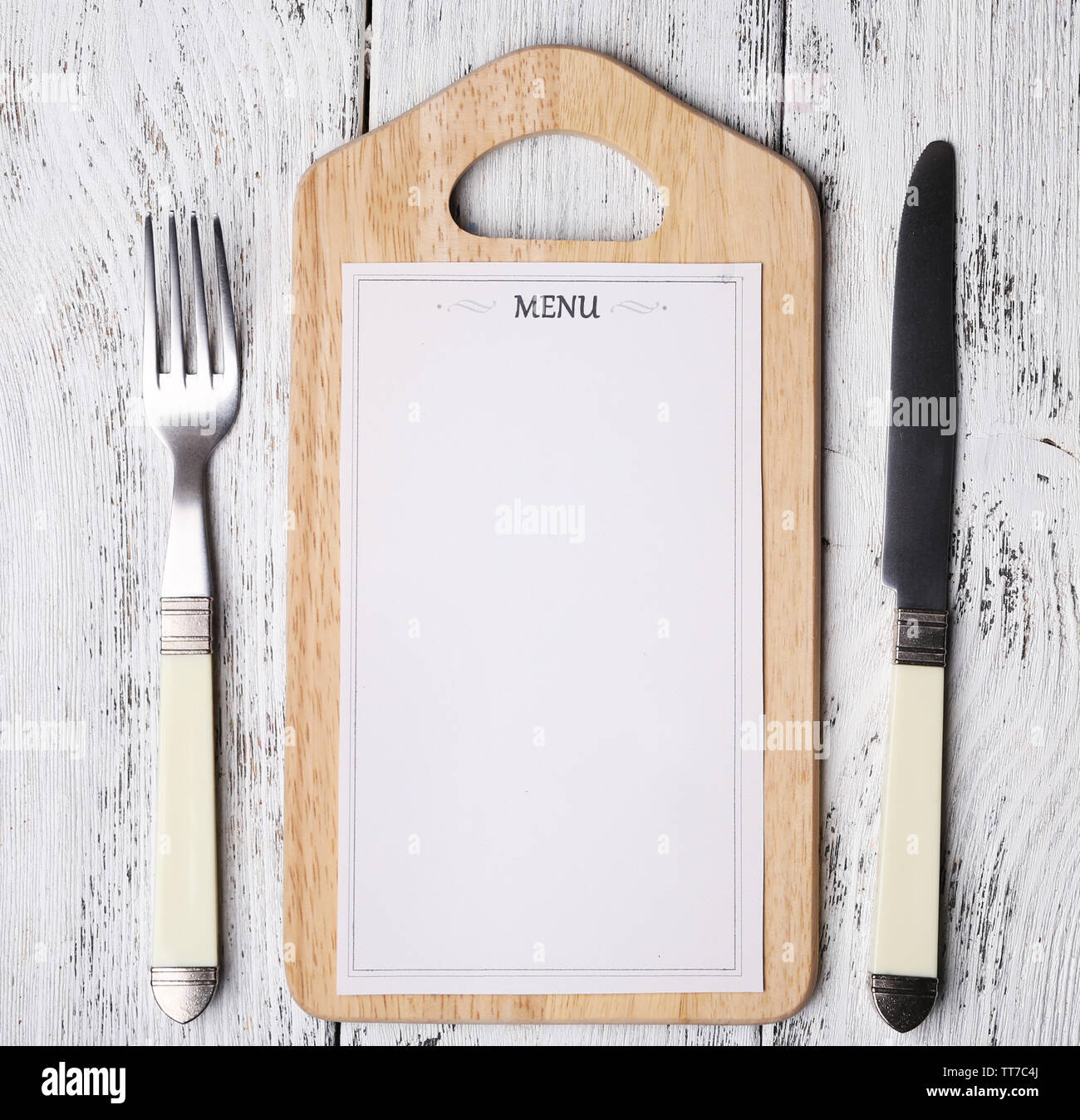 Cutting board with menu sheet of paper on color wooden background Stock ...