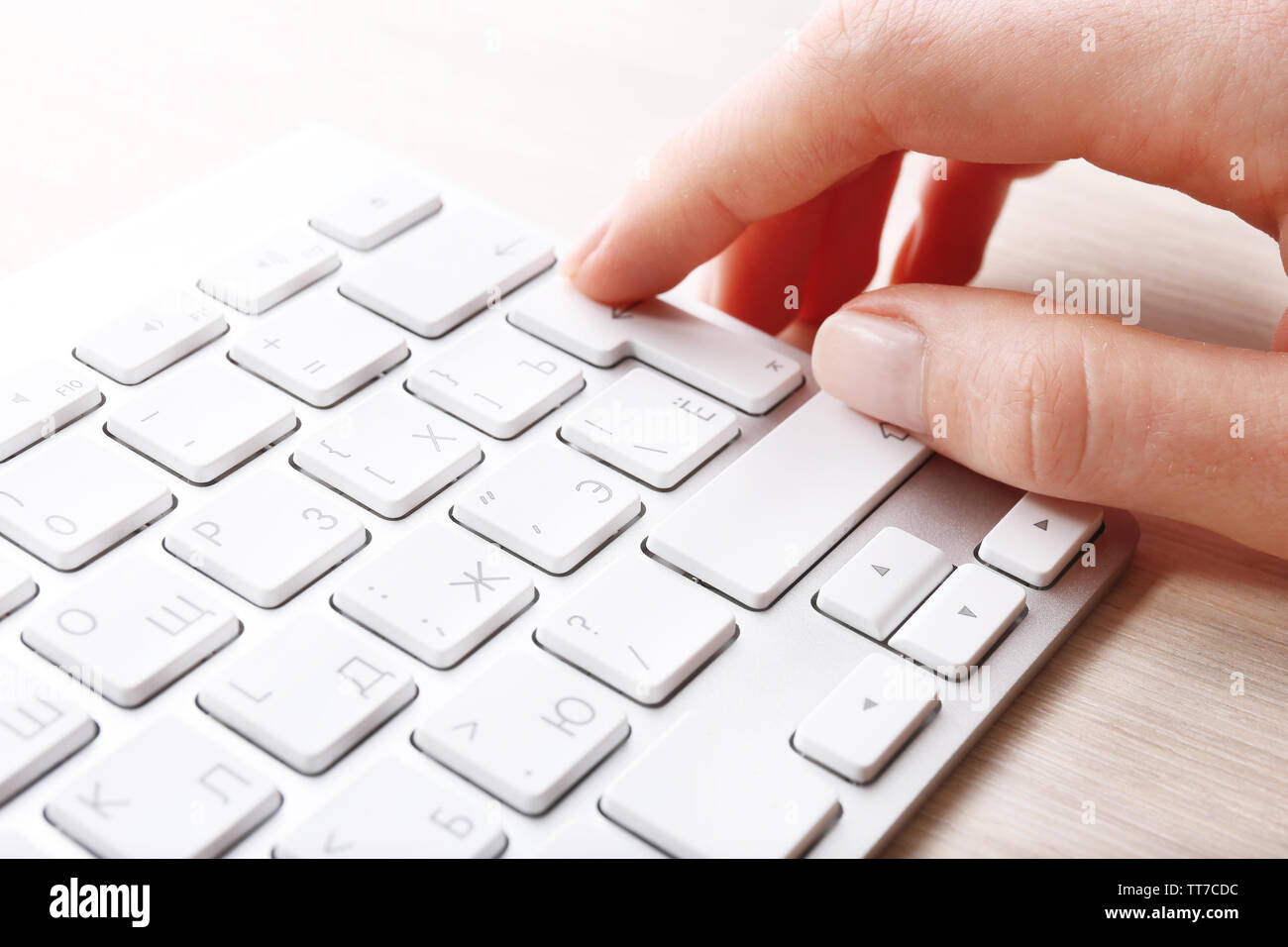 Female hand with keyboard on wooden desktop background Stock Photo - Alamy