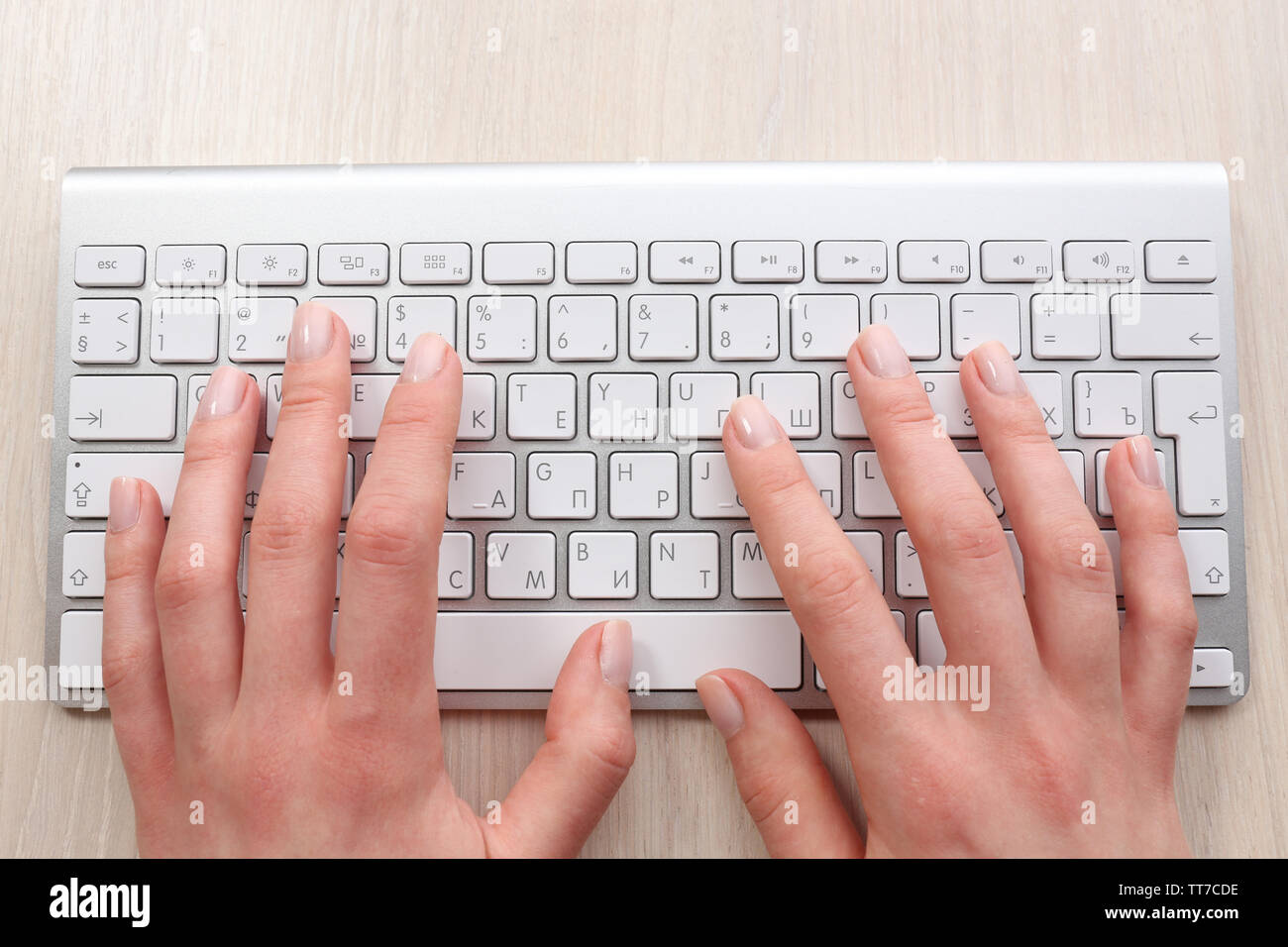 Female hands with keyboard on wooden desktop background Stock Photo - Alamy