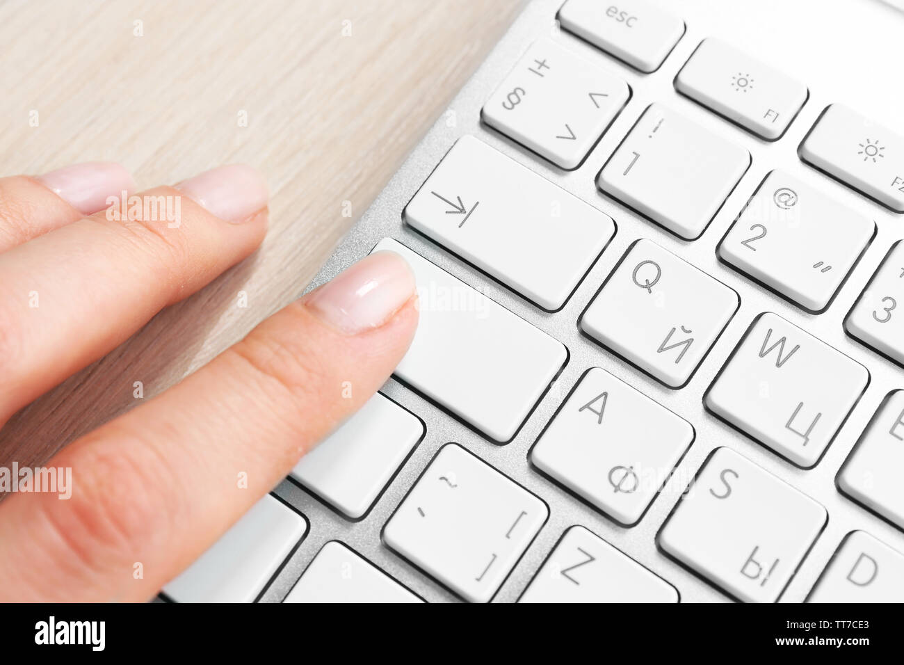 Female hand with keyboard on wooden desktop background Stock Photo - Alamy