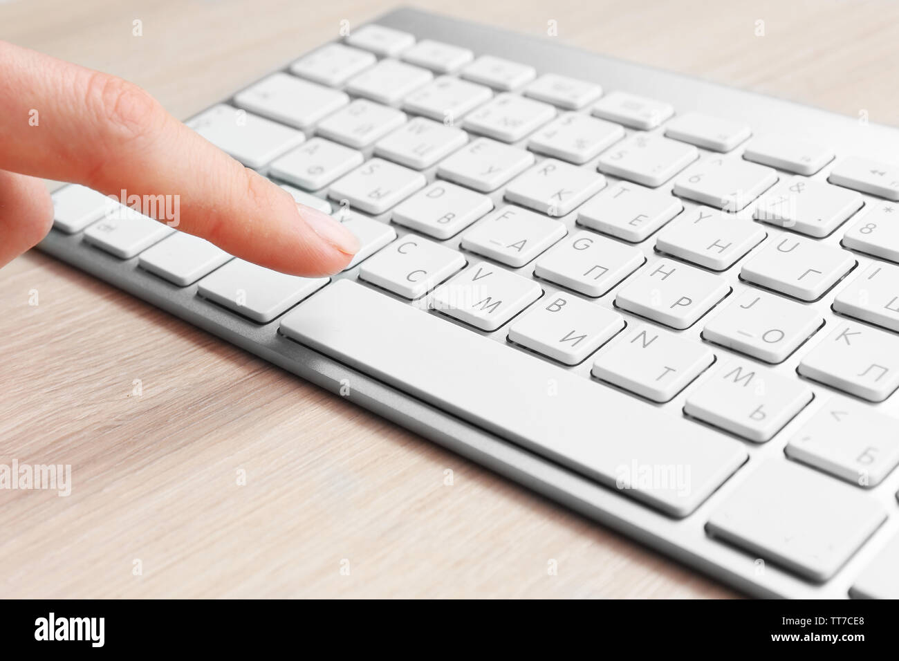 Female hand with keyboard on wooden desktop background Stock Photo - Alamy
