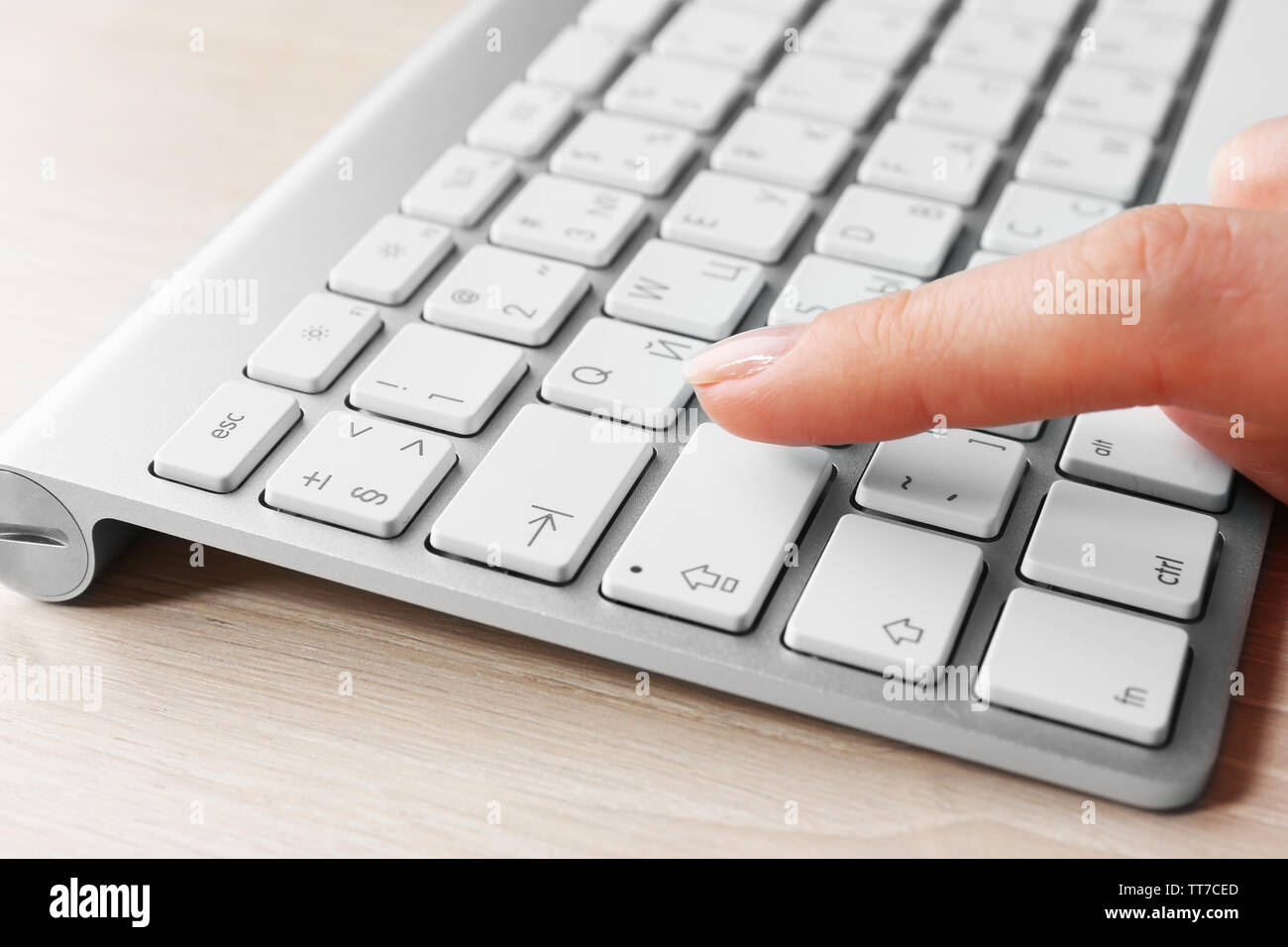 Female hand with keyboard on wooden desktop background Stock Photo - Alamy