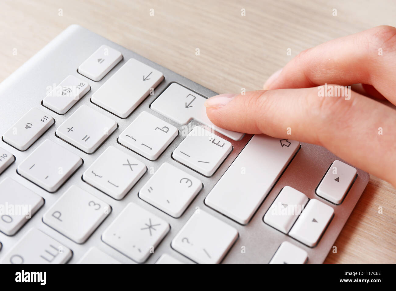 Female hand with keyboard on wooden desktop background Stock Photo - Alamy