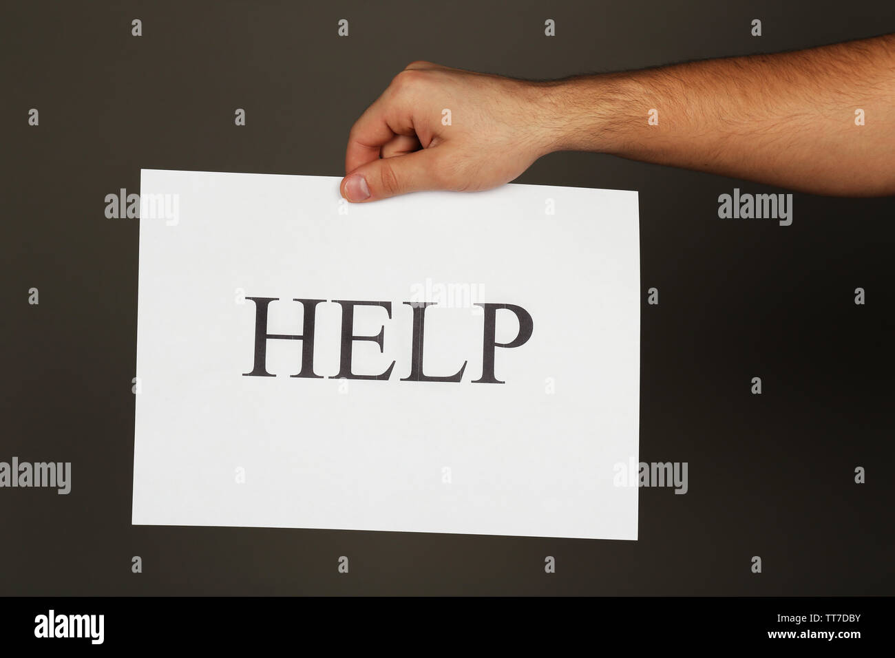Sheet of paper with Help sign in male hand on dark background Stock ...