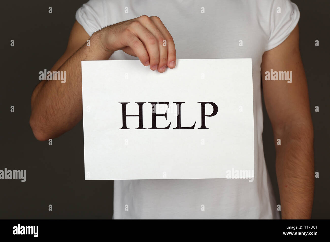 Sheet of paper with Help sign in male hand on dark background Stock ...