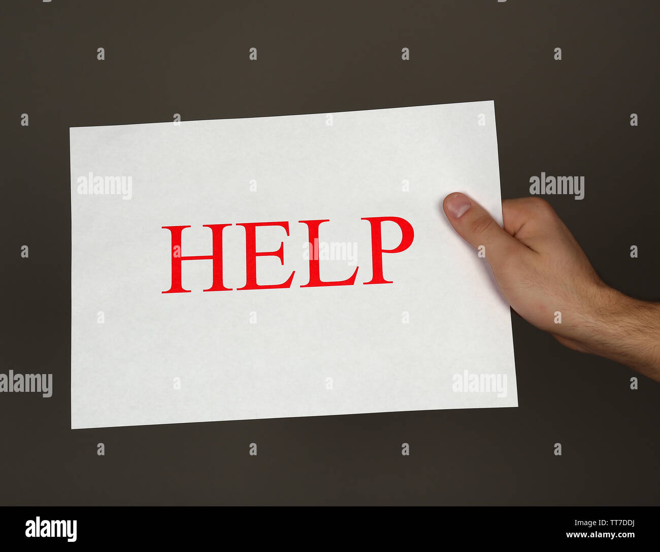 Sheet of paper with Help sign in male hand on dark background Stock ...