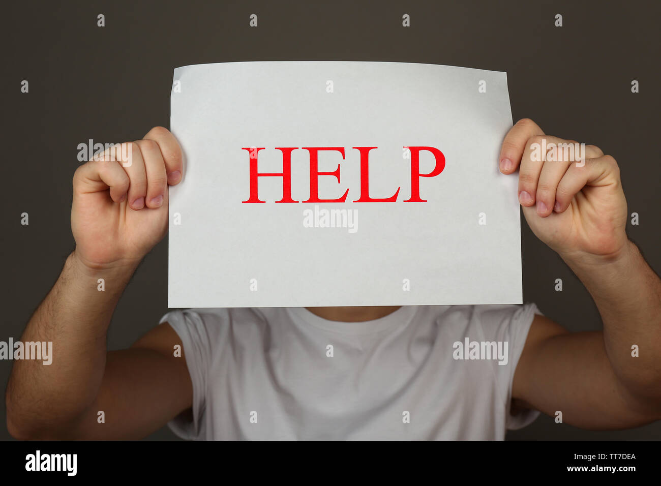 Sheet of paper with Help sign in male hands on dark background Stock ...