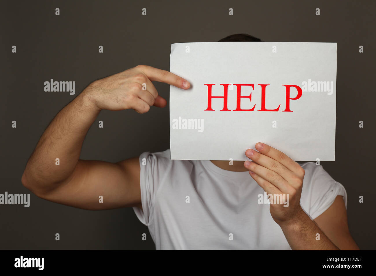 Sheet of paper with Help sign in male hands on dark background Stock ...