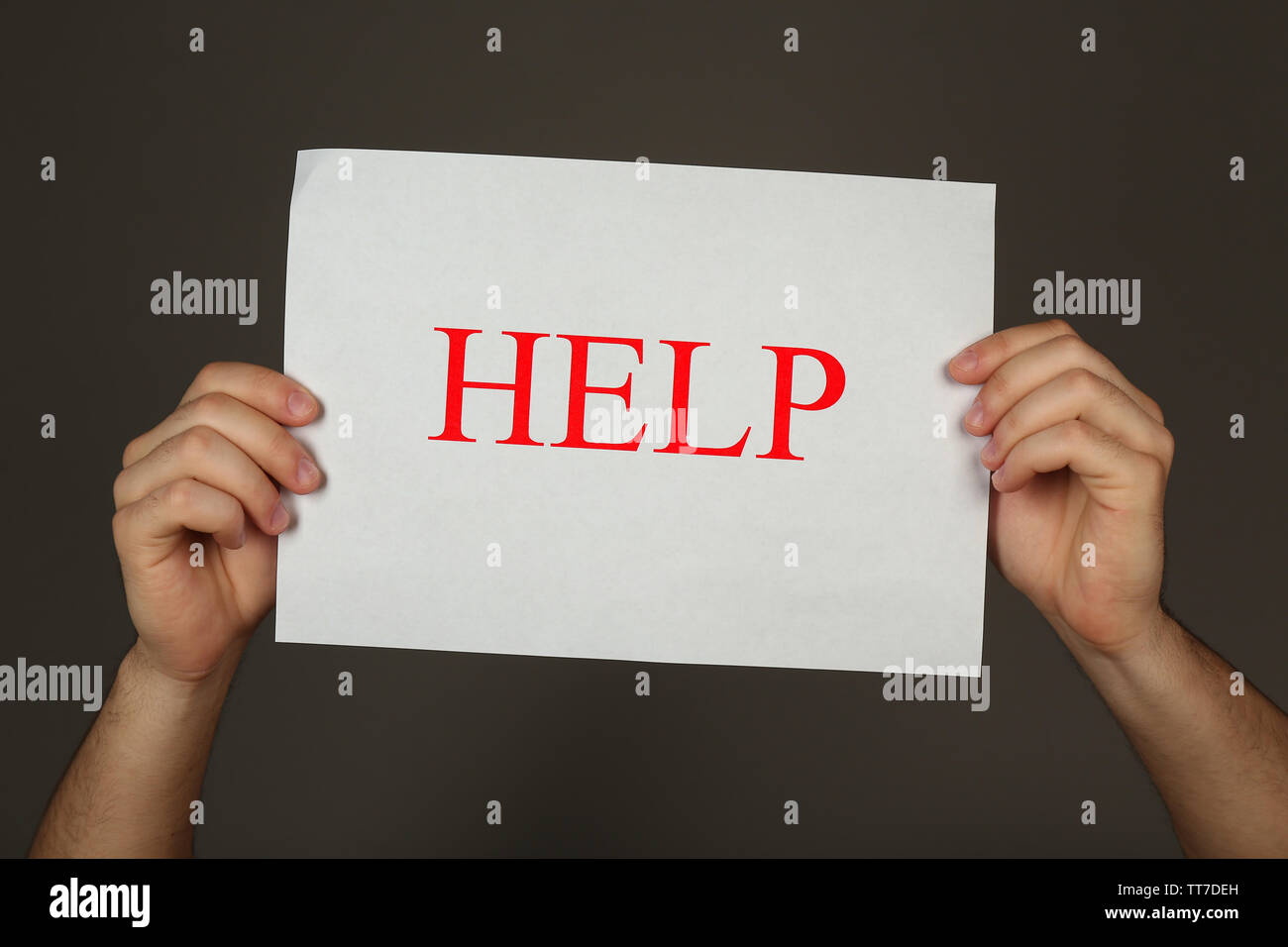 Sheet of paper with Help sign in male hands on dark background Stock ...