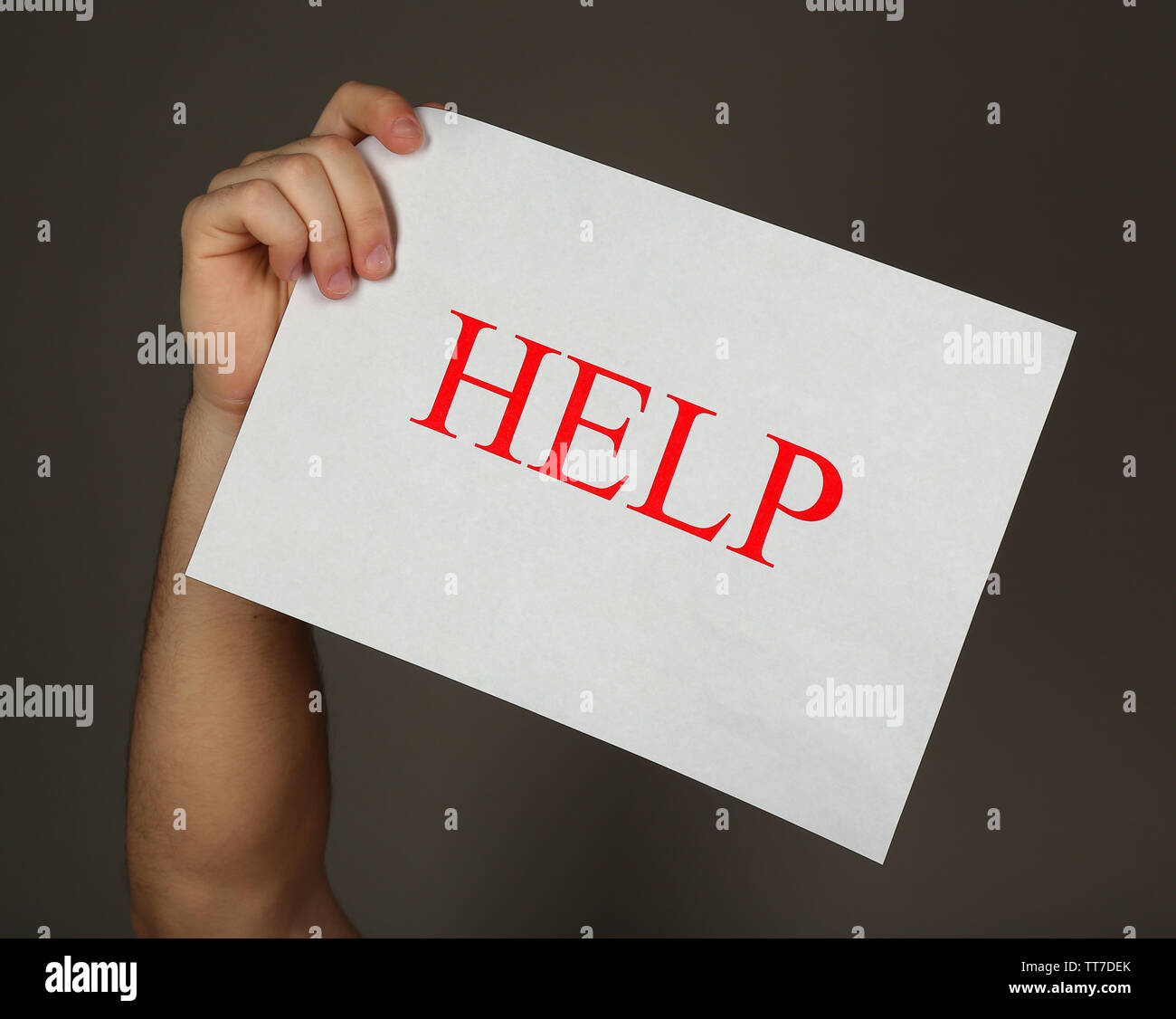 Sheet of paper with Help sign in male hand on dark background Stock ...