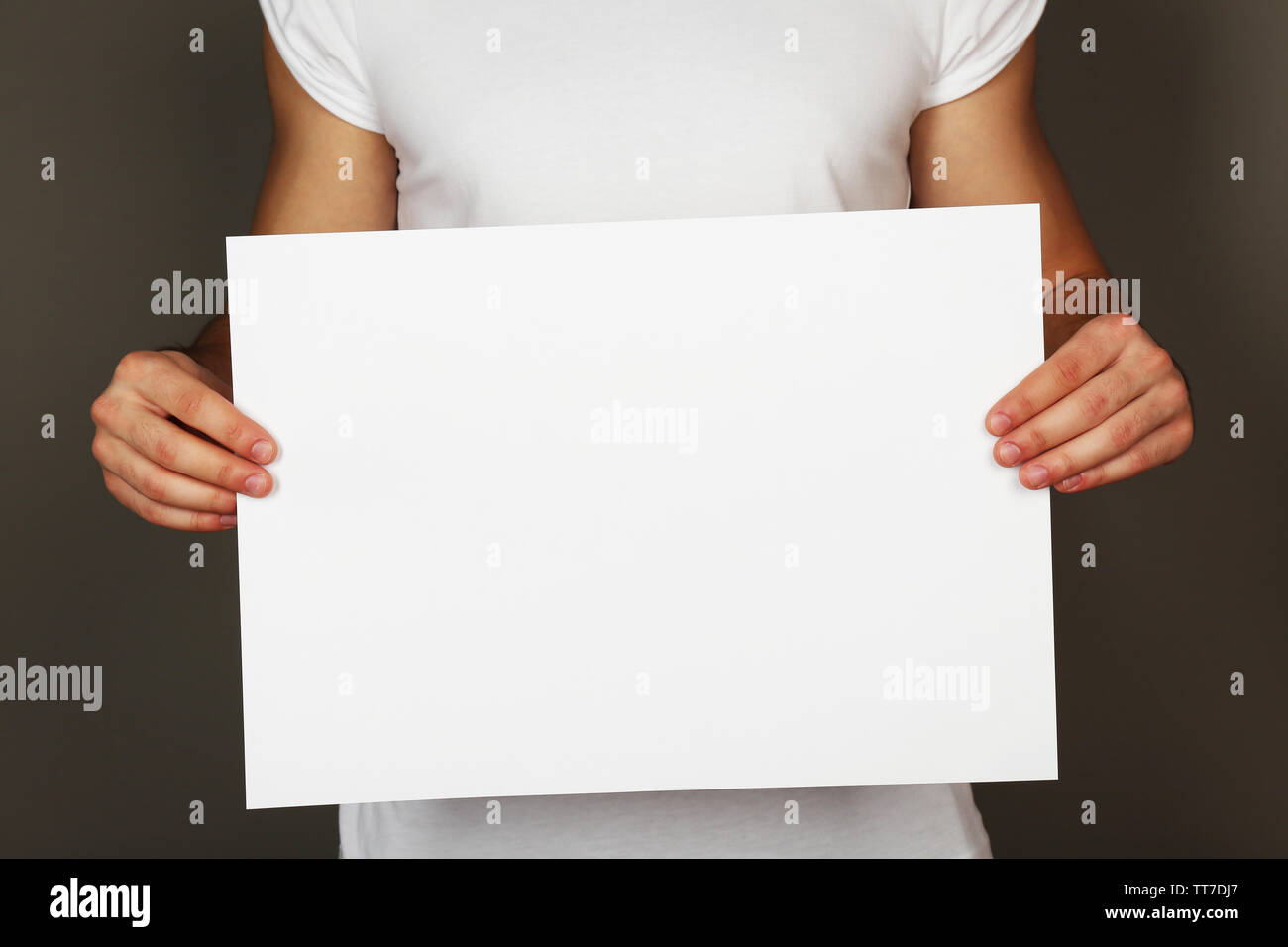 Blank sheet of paper in male hands on dark background Stock Photo - Alamy