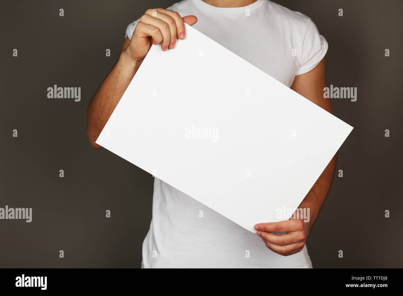 Blank sheet of paper in male hands on dark background Stock Photo - Alamy