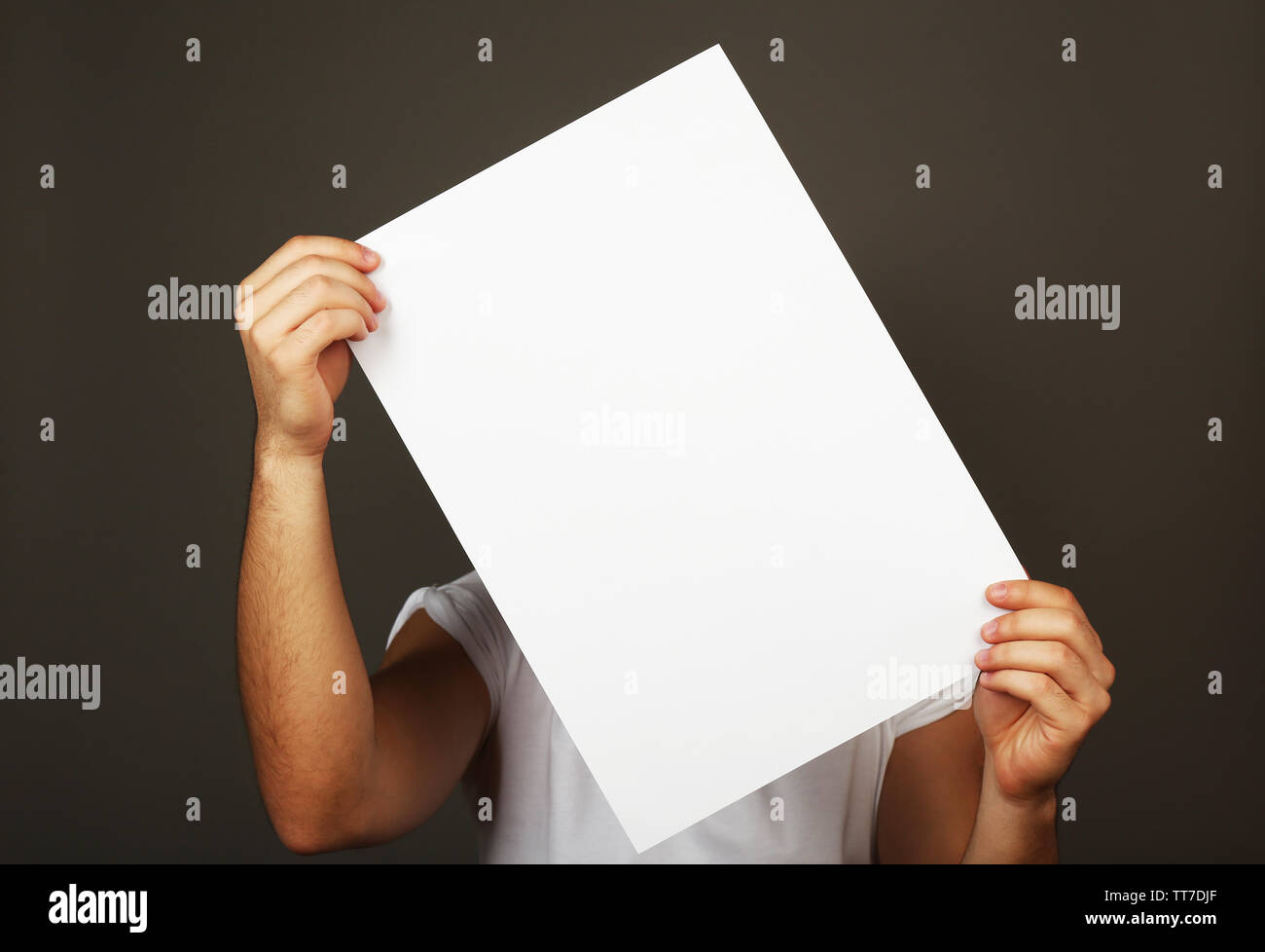 Blank sheet of paper in male hands on dark background Stock Photo - Alamy