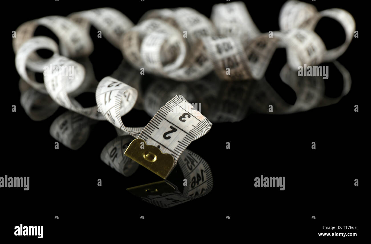 Measuring tape on black background Stock Photo - Alamy