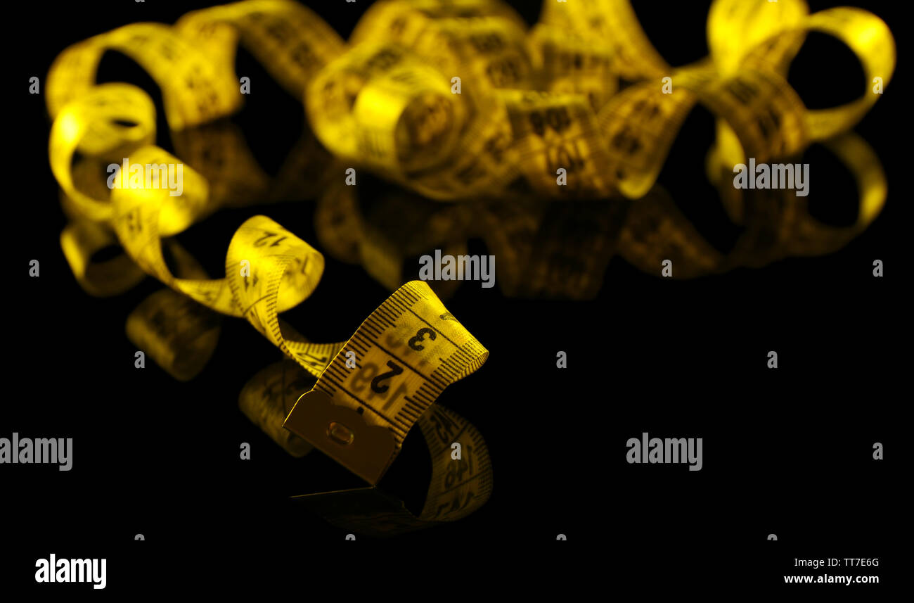 Measuring tape on black background Stock Photo - Alamy
