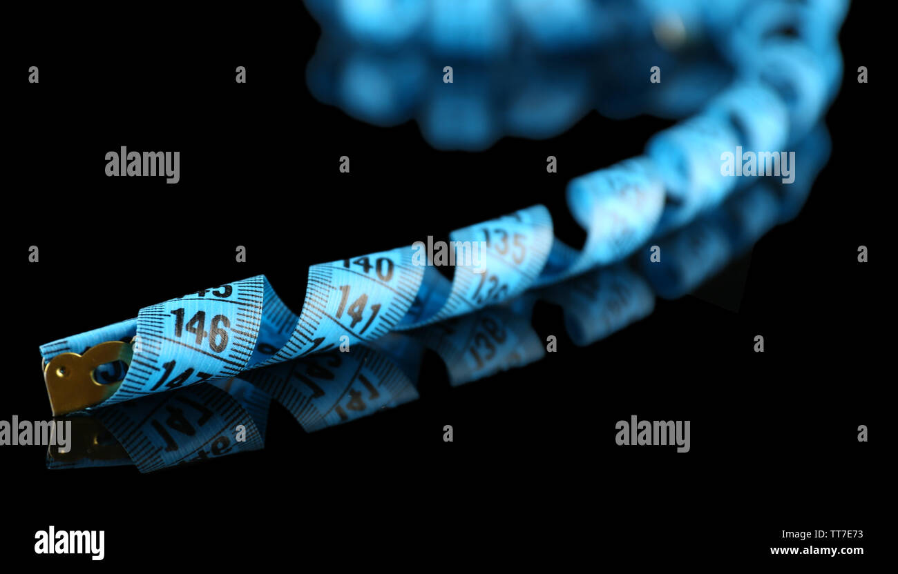 Measuring tape on black background Stock Photo - Alamy
