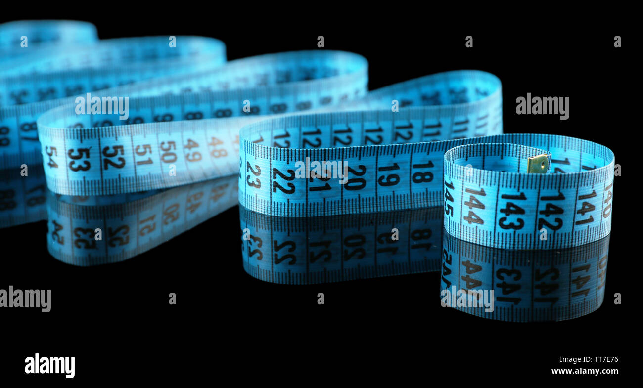 Measuring tape on black background Stock Photo - Alamy