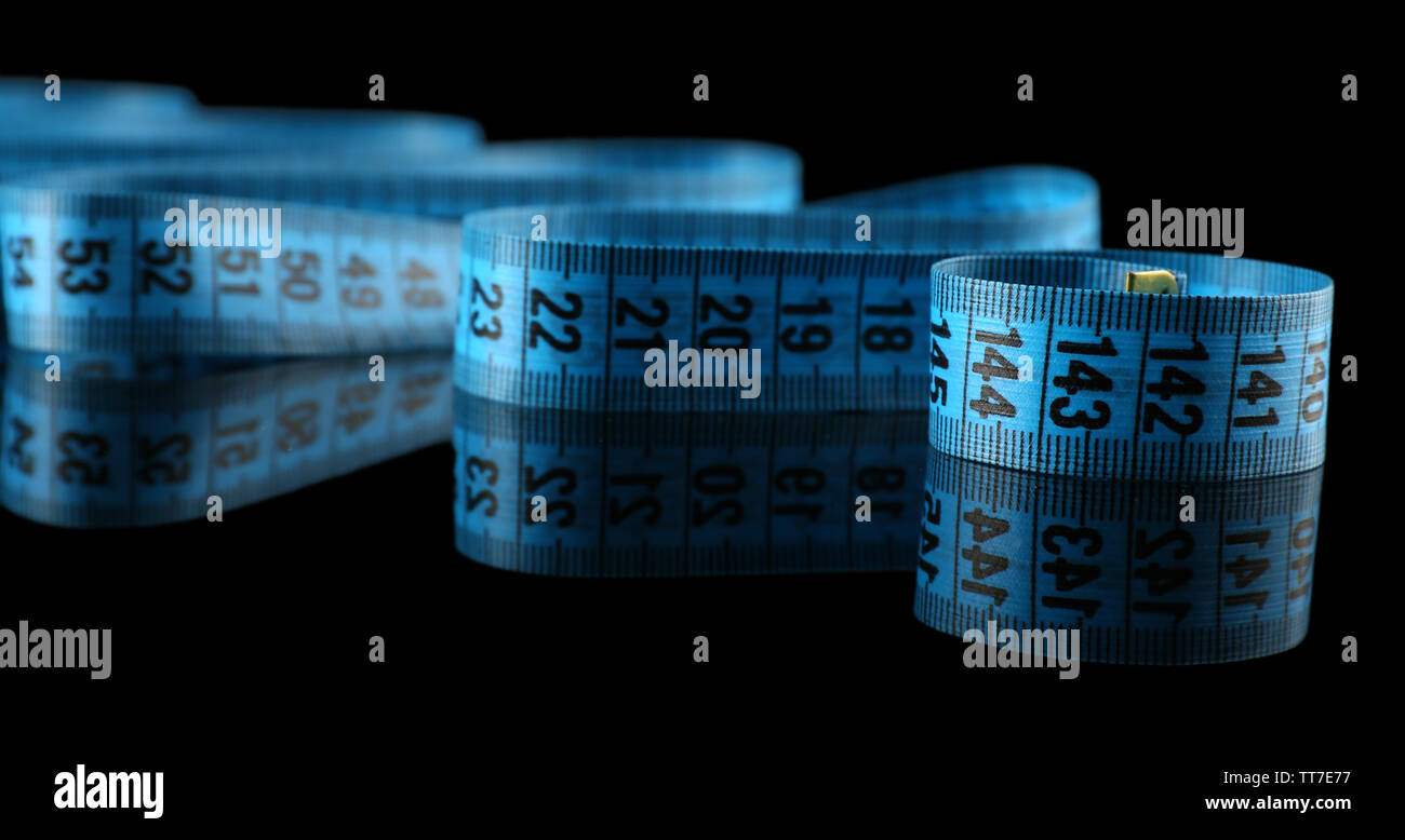 Measuring tape on black background Stock Photo - Alamy