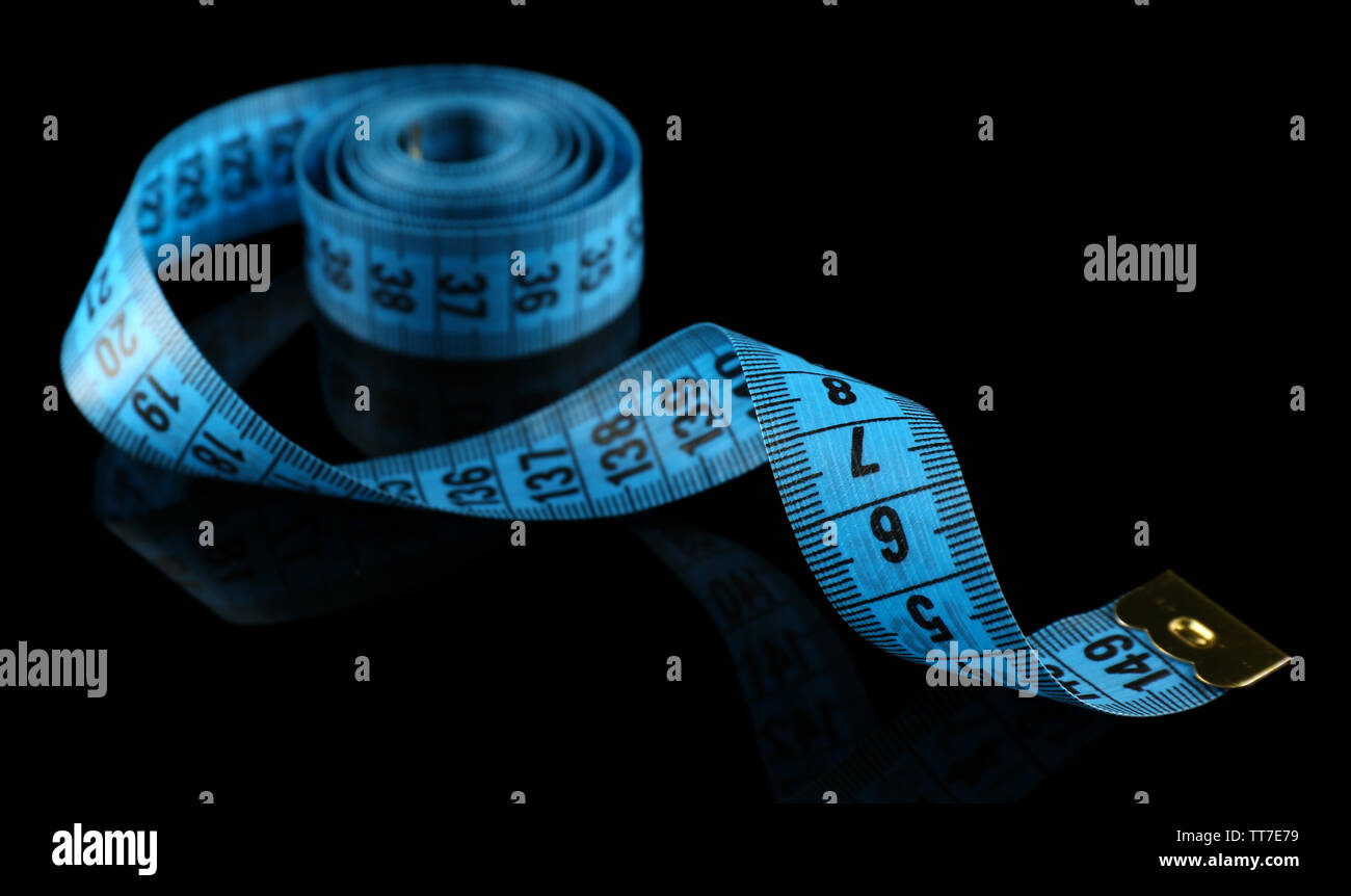Measuring tape on black background Stock Photo - Alamy