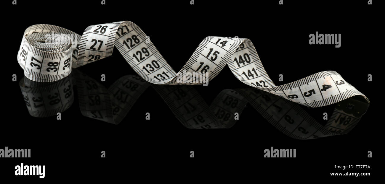 Measuring tape on black background Stock Photo - Alamy