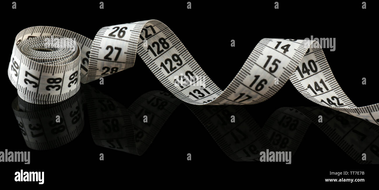Measuring tape on black background Stock Photo - Alamy