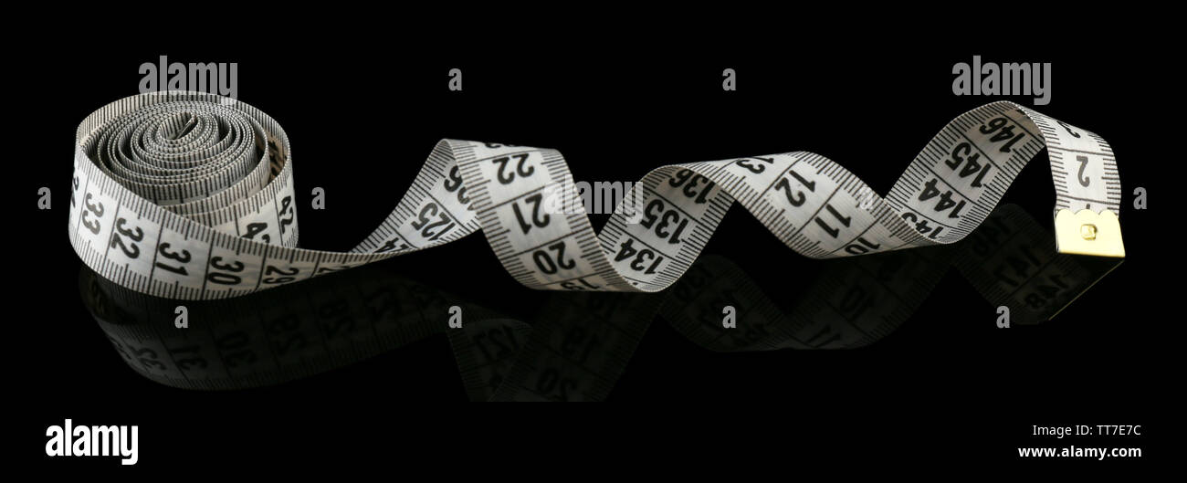 Measuring tape on black background Stock Photo - Alamy