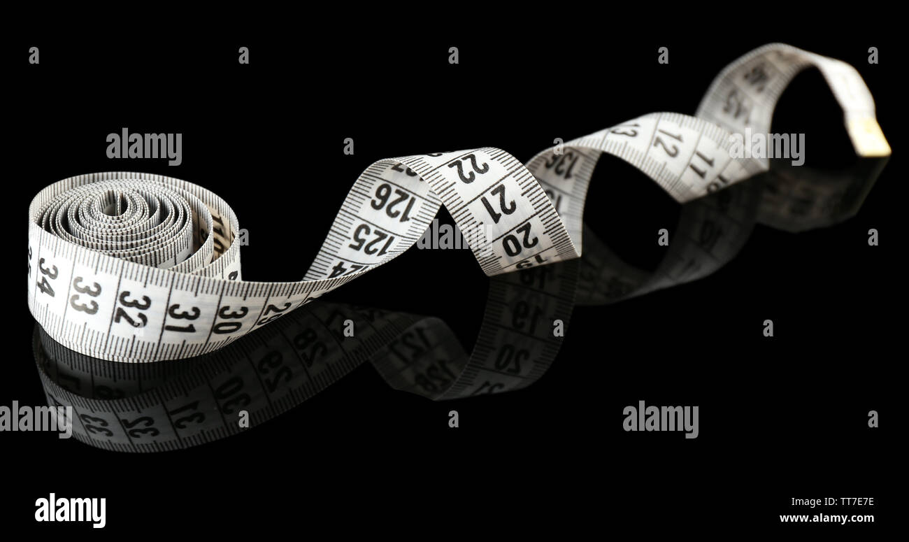 Measuring tape on black background Stock Photo - Alamy