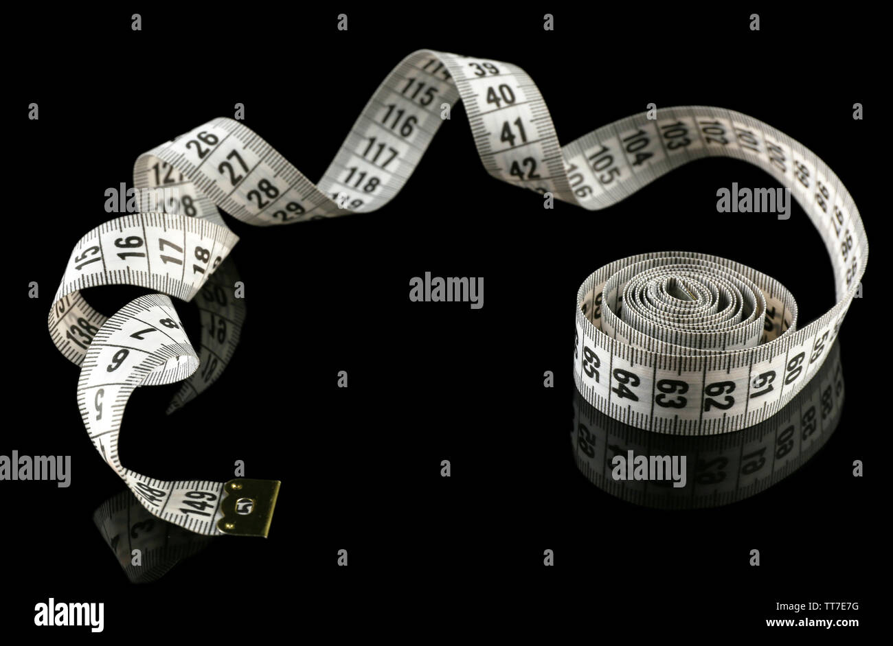 Measuring tape on black background Stock Photo - Alamy