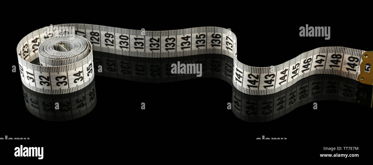 Measuring tape on black background Stock Photo - Alamy