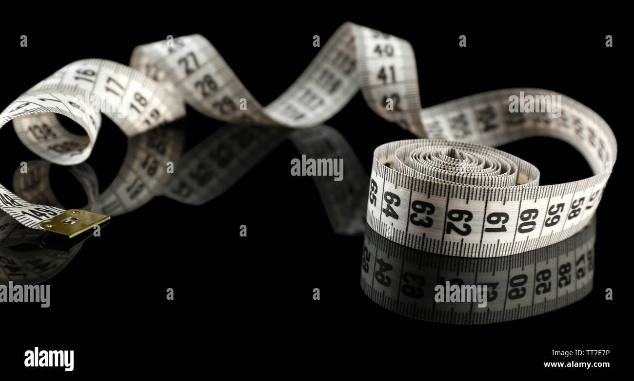 Measuring tape on black background Stock Photo - Alamy