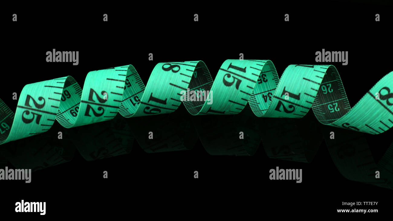 Measuring tape on black background Stock Photo - Alamy