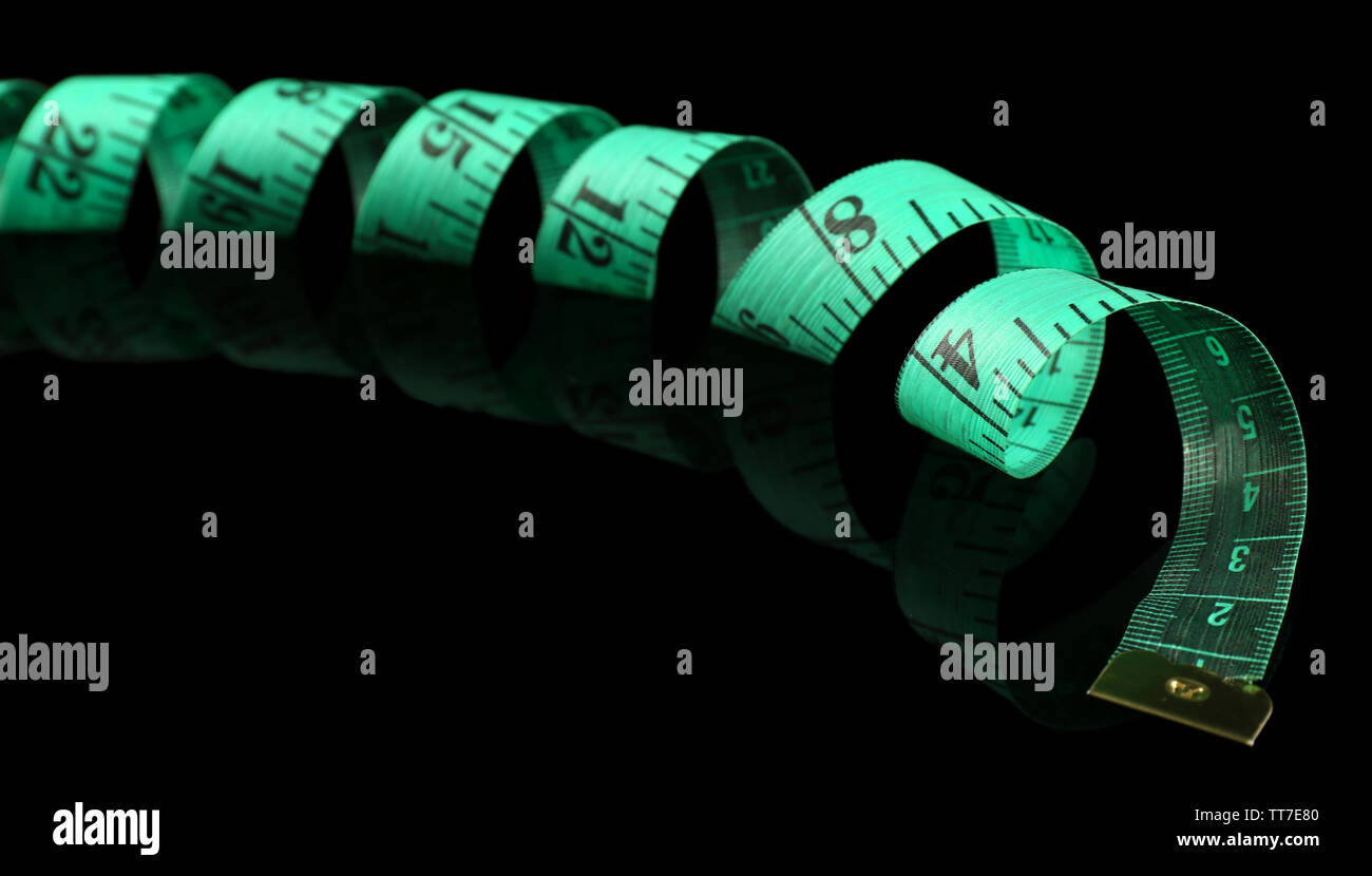 Measuring tape on black background Stock Photo - Alamy