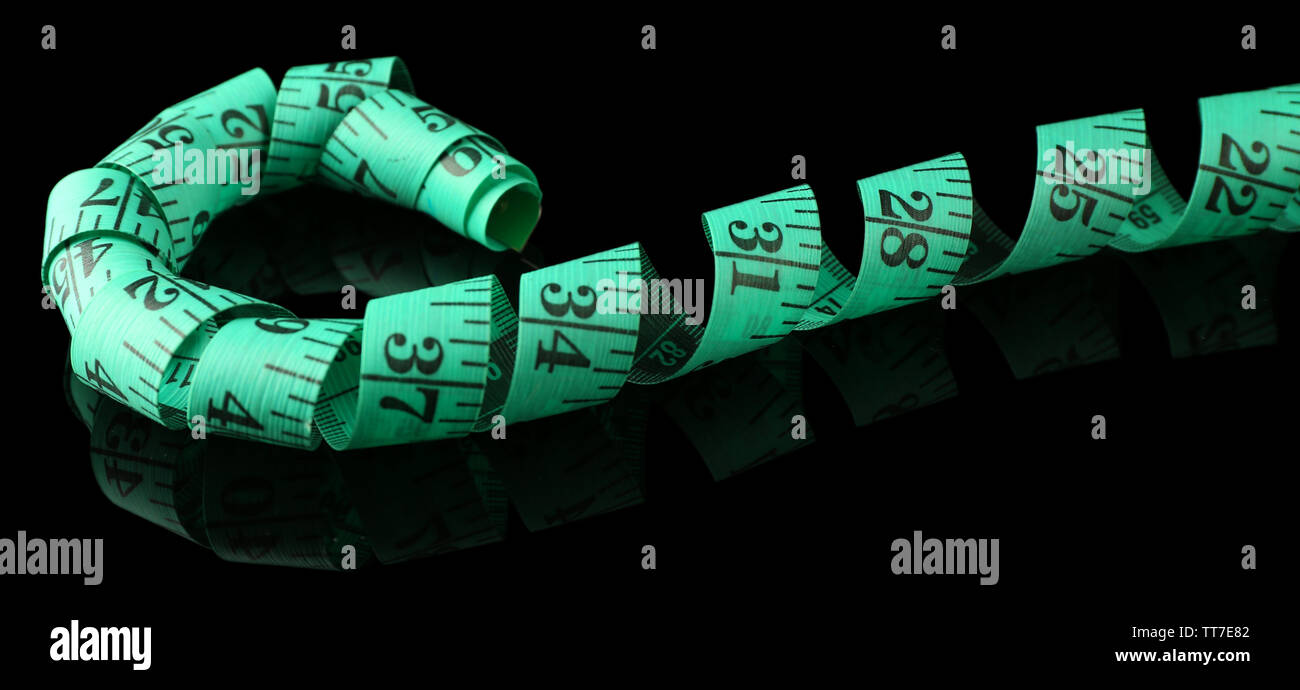 Measuring tape on black background Stock Photo - Alamy