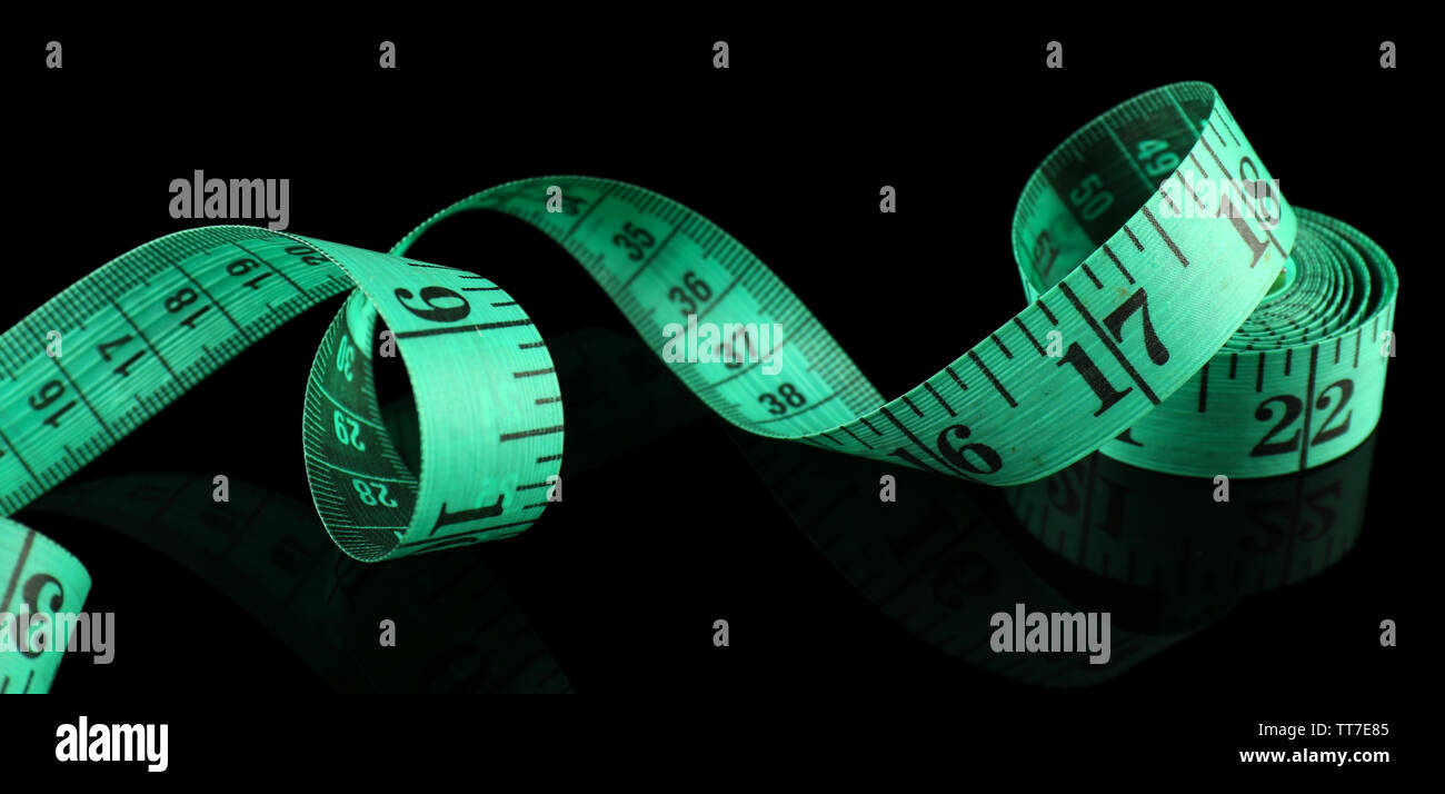 Measuring tape on black background Stock Photo - Alamy