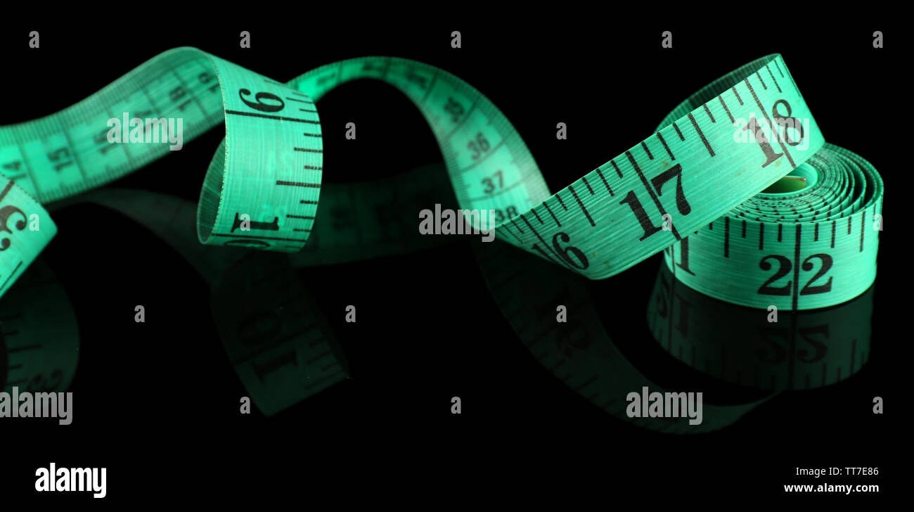 Measuring tape on black background Stock Photo - Alamy