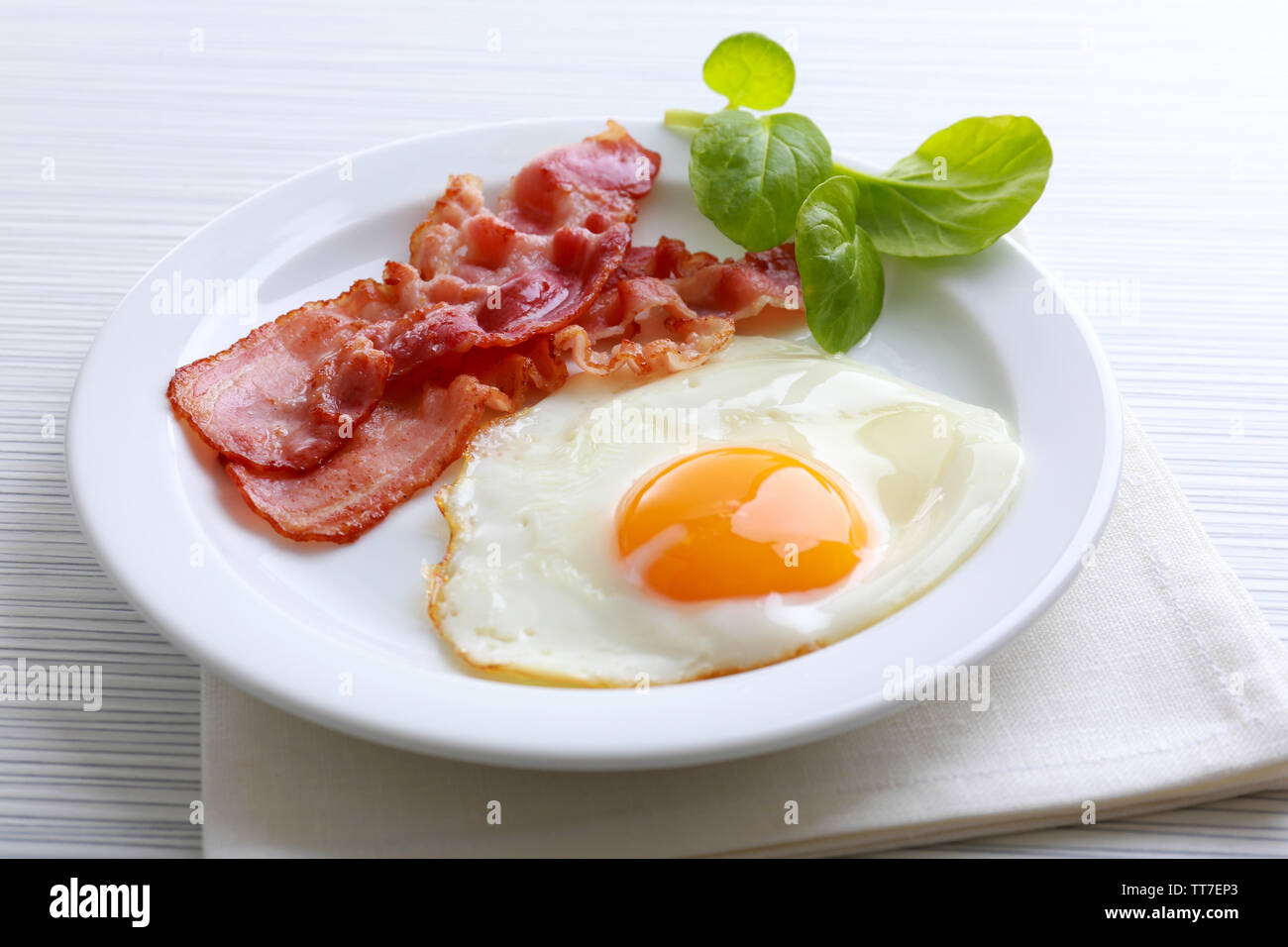 Bacon and eggs on color wooden table background Stock Photo - Alamy
