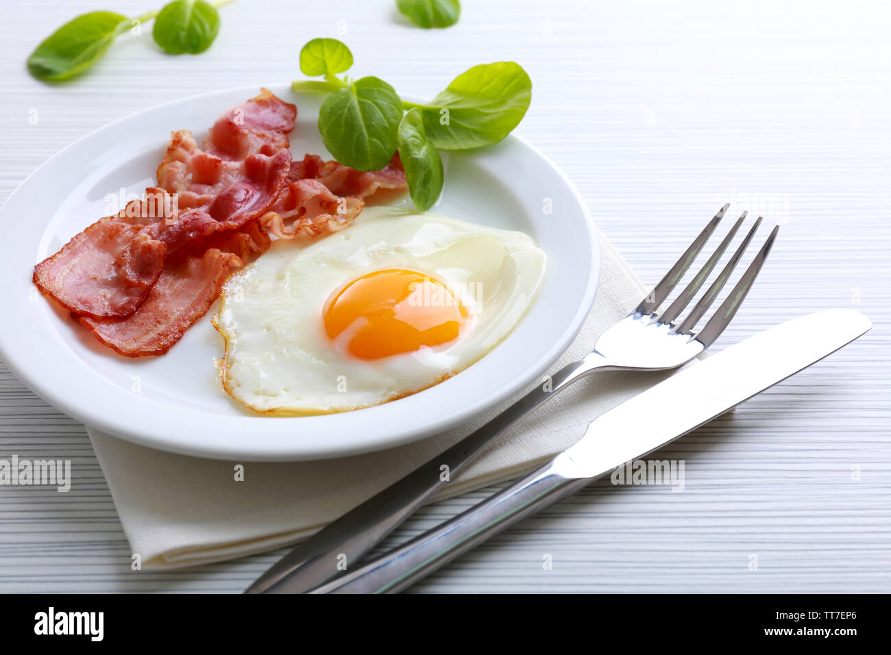 Bacon and eggs on color wooden table background Stock Photo - Alamy
