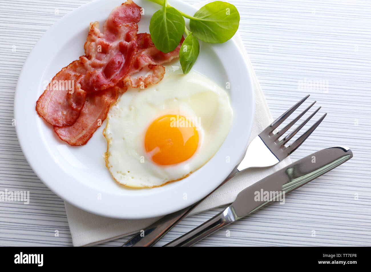 Bacon and eggs on color wooden table background Stock Photo - Alamy