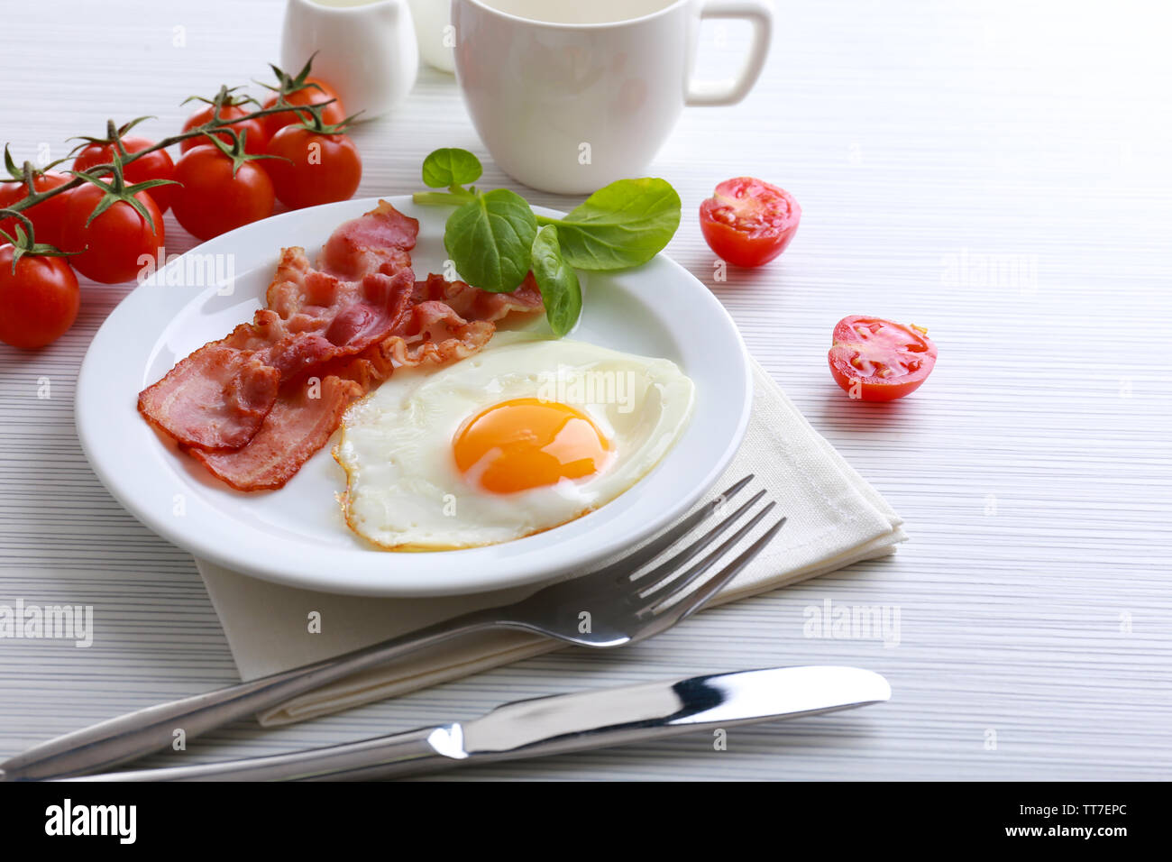 Bacon and eggs on color wooden table background Stock Photo - Alamy