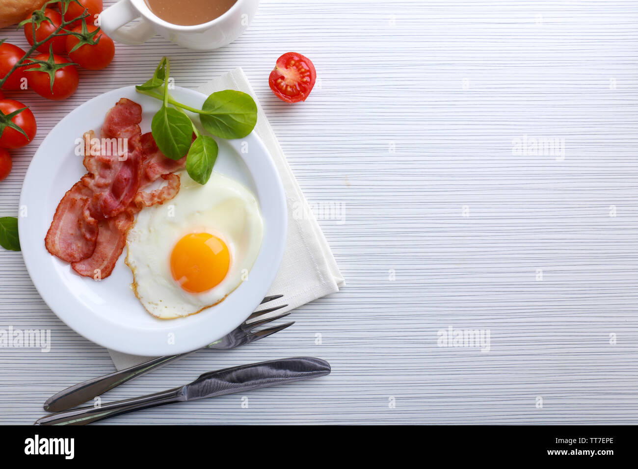 Bacon and eggs on color wooden table background Stock Photo - Alamy