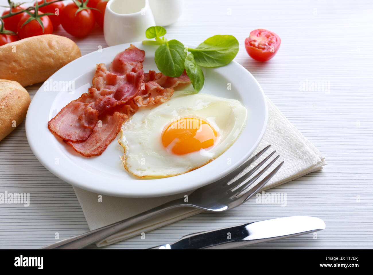 Bacon and eggs on color wooden table background Stock Photo - Alamy