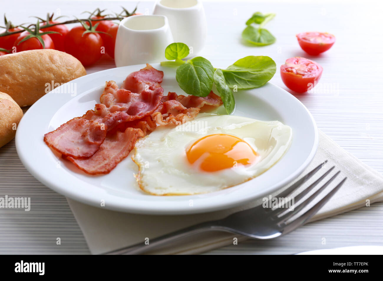 Bacon and eggs on color wooden table background Stock Photo - Alamy