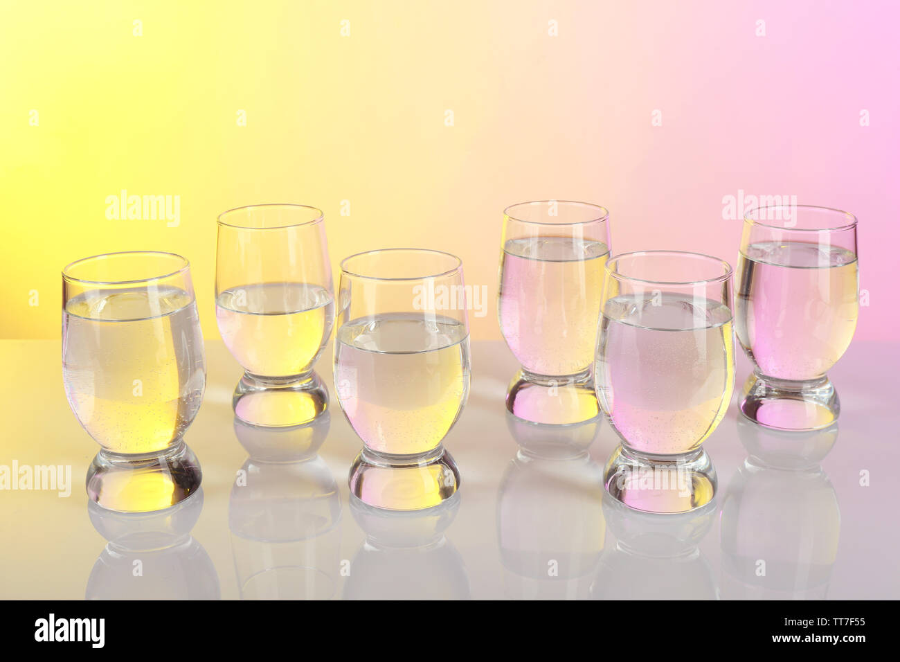 Glasses of water on table and colorful background Stock Photo - Alamy