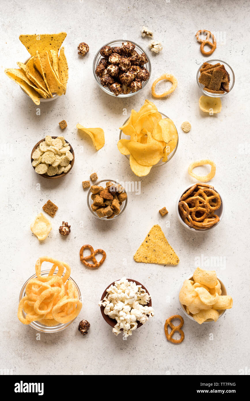 Assortment of Unhealthy Snacks: chips, popcorn, nachos, pretzels, onion ...
