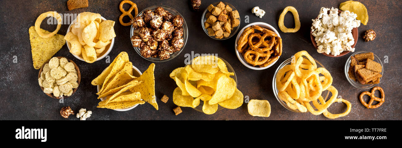 Assortment of Unhealthy Snacks: chips, popcorn, nachos, pretzels, onion ...