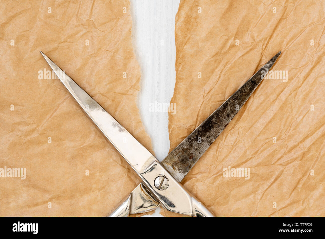 Scissors on brown paper background. Separation concept Stock Photo - Alamy