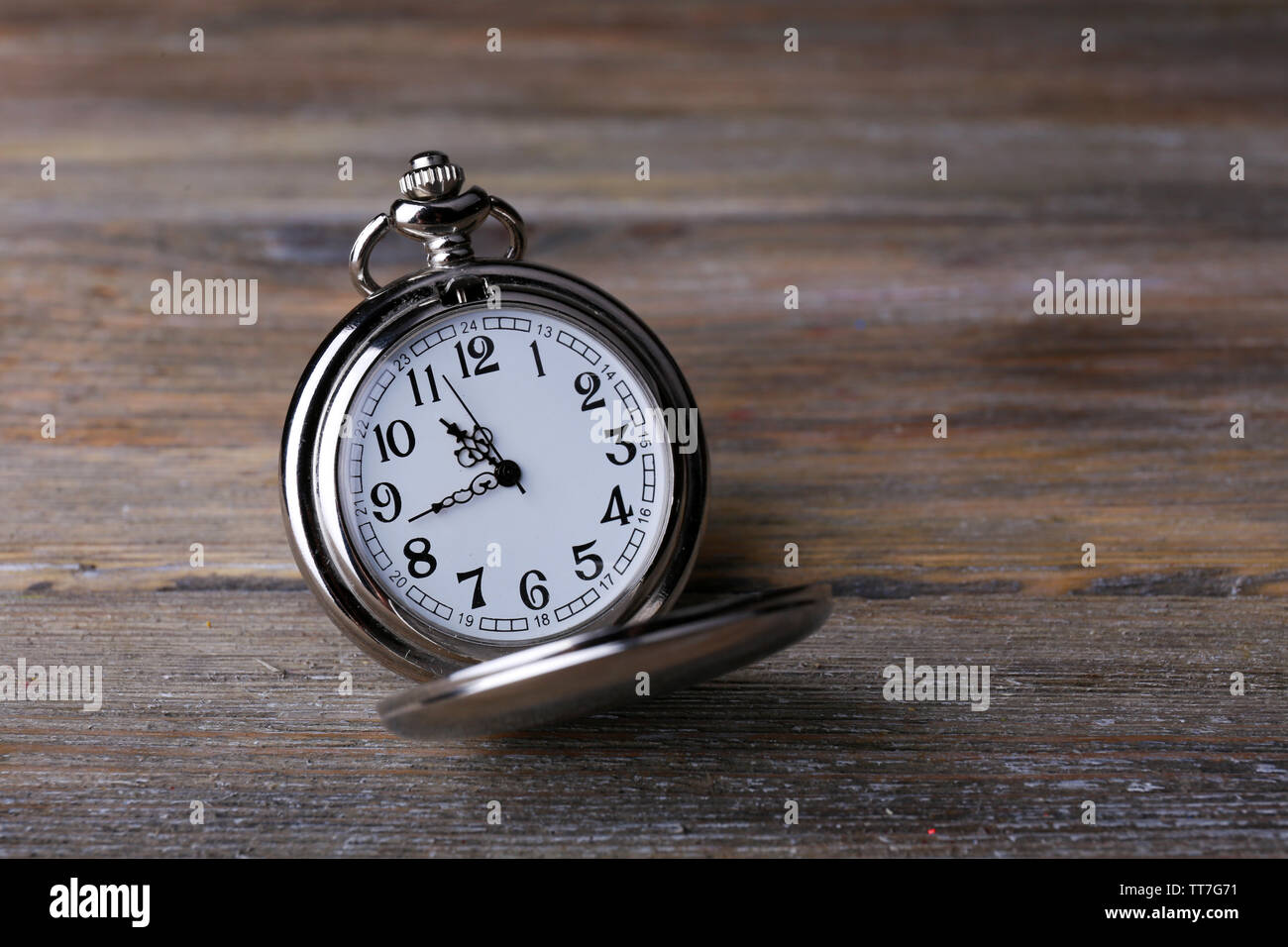 Silver pocket clock on wooden background Stock Photo - Alamy