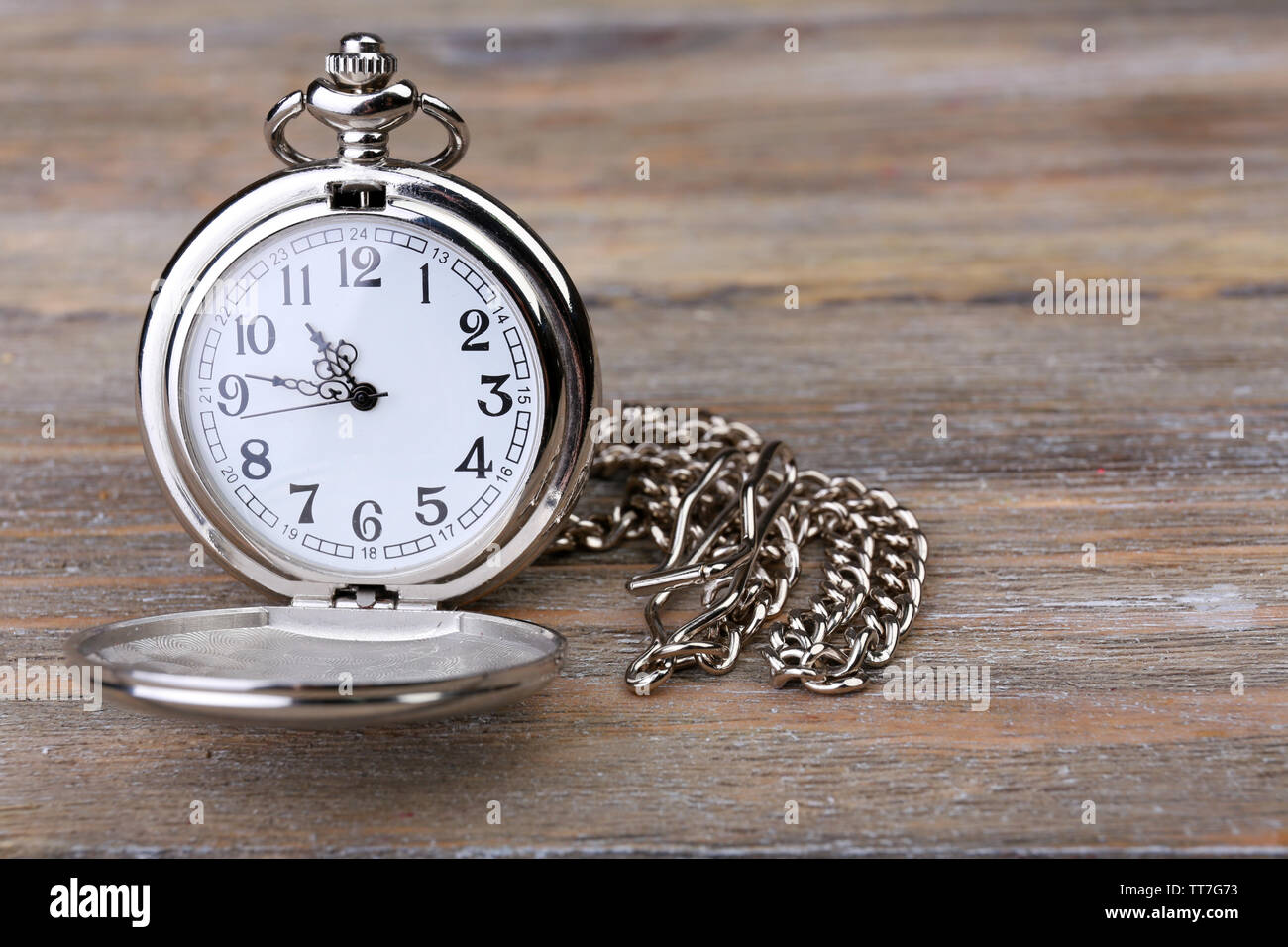 Silver pocket clock on wooden background Stock Photo - Alamy