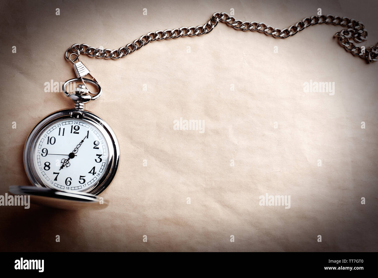 Silver pocket clock on old paper background Stock Photo - Alamy